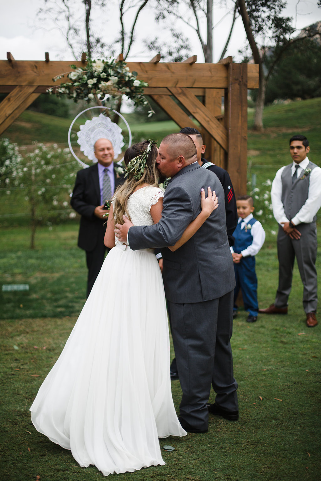 A romantic garden ceremony with a uniformed groom and boho bride ...