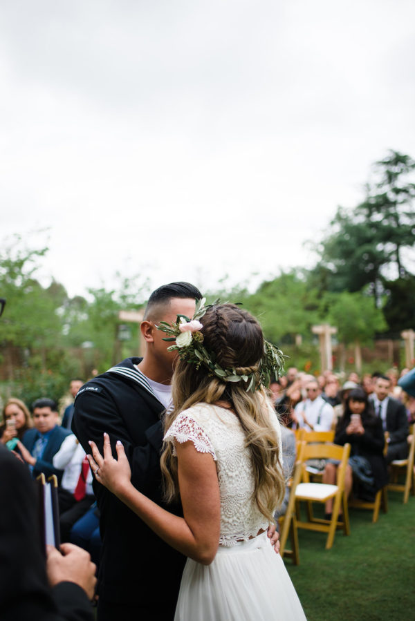 A romantic garden ceremony with a uniformed groom and boho bride ...